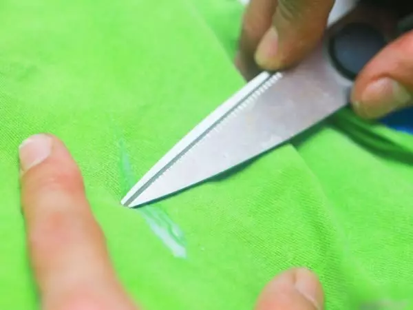 Škare uklanjaju stazu iz PVA sa zelenom tkaninom