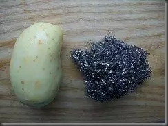 Paglilinis ng mga batang patatas na may metal kitchen sponge.