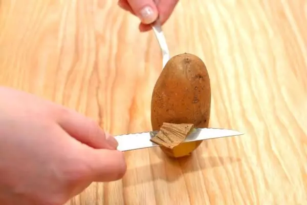 Valymas virtos bulvės su peiliu