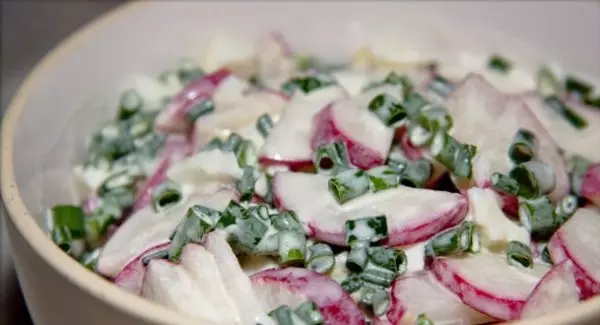 Salāti no olām, zaļiem sīpoliem un redīsiem ar skābo krējumu bļodā