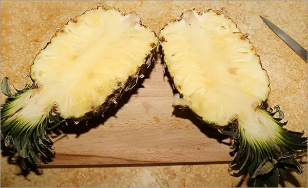 Cortar a metade de ananás nunha tarxeta de corte