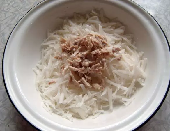 Curly dycon and pieces of boiled chicken meat in a bowl