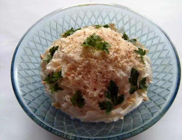 Salotos su Dikecon ir sūriu salotos dubenyje, papuoštas šviežiais petražolėmis