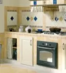 Køkken, vægge og gulv, der er dekoreret beige og hvide fliser