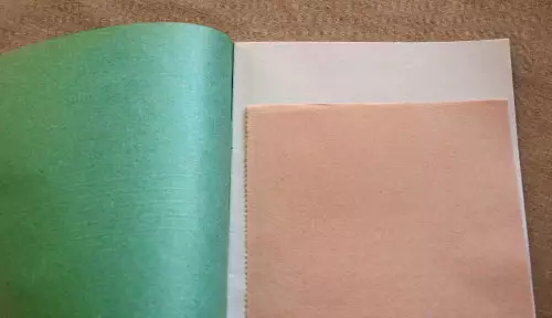 Różowy blotting na otwartym notebooku z zieloną pokrywą