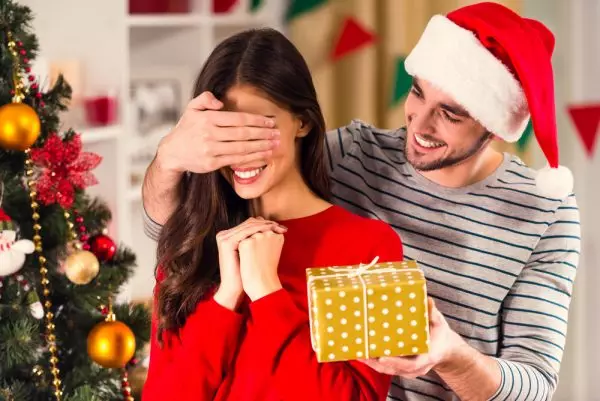 Un hombre da un regalo a una mujer de Año Nuevo.