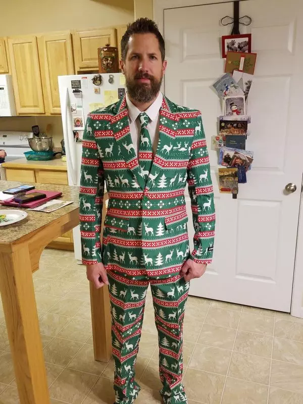 Človek v kostumu s božičnim natisom