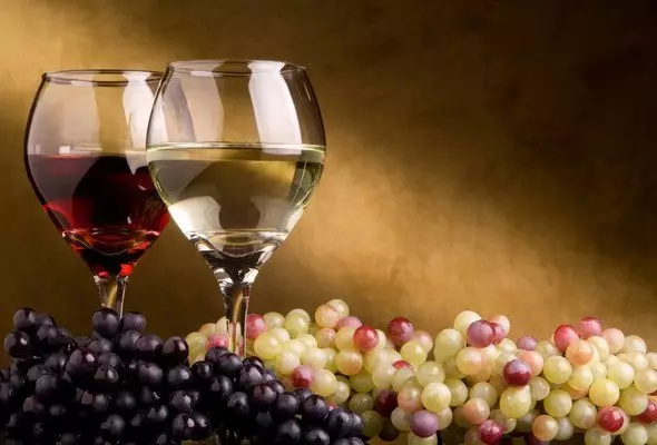 2 bicchieri con vino bianco e rosso, uva oscura e bianca