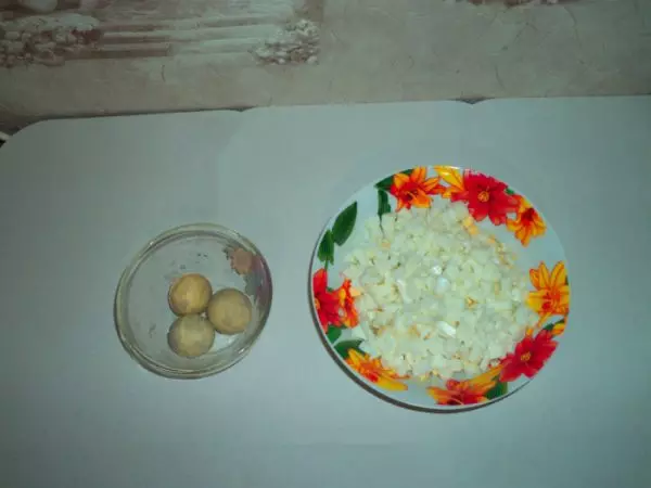Gekookte eiergele in glas tenk en gekapte eiers in 'n bord