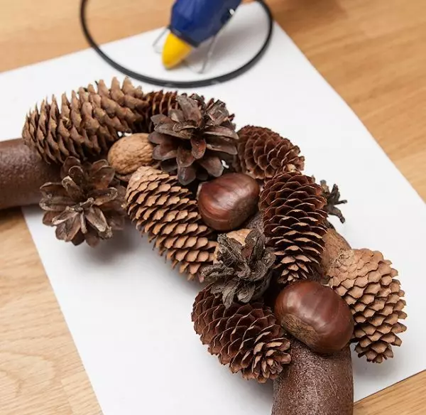 Formation of a festive wreath of cones, nuts and chestnuts