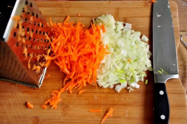 Moler cebollas y zanahorias en una tabla de cortar.