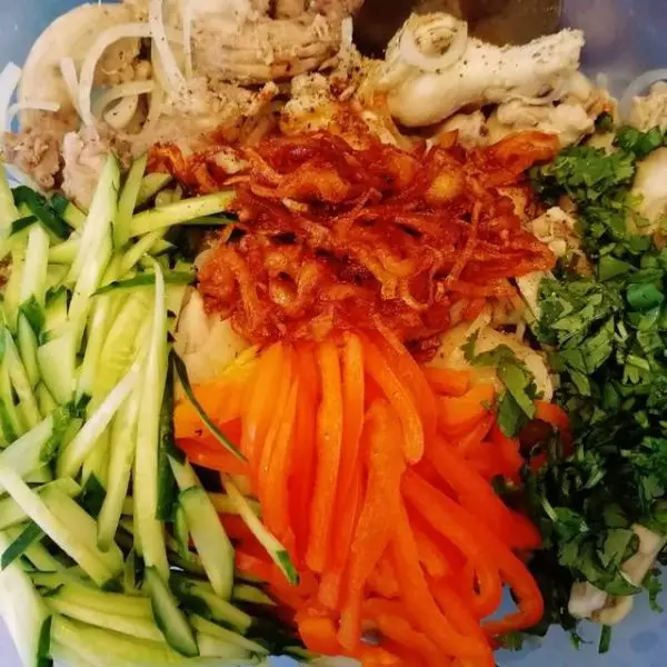 Kepingan ayam rebus, sayur-sayuran segar dan digoreng dengan bawang rempah dalam mangkuk