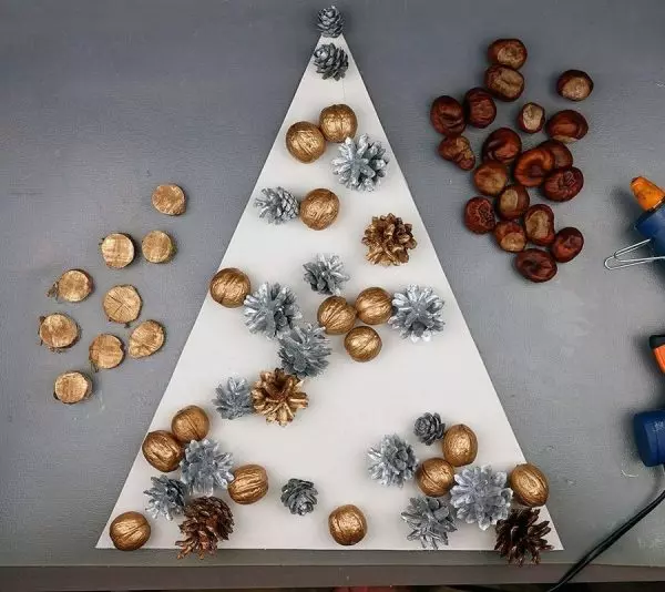 Målade guld och silver spray stötar och valnötter på en kartongräkning för julgran