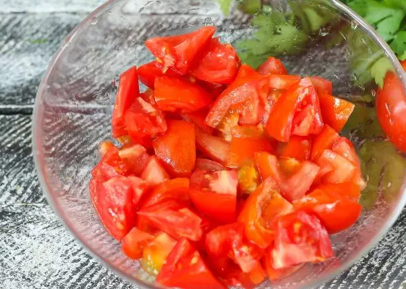 Viilutatud küpsed tomatid tabelis klaasikaussi