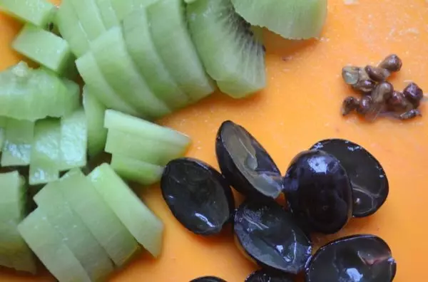 Kiwi parçaları və soyulmuş üzümün yarısı