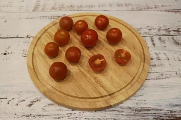 Dəyirmi kəsmə taxta lövhəsində albalı pomidorları