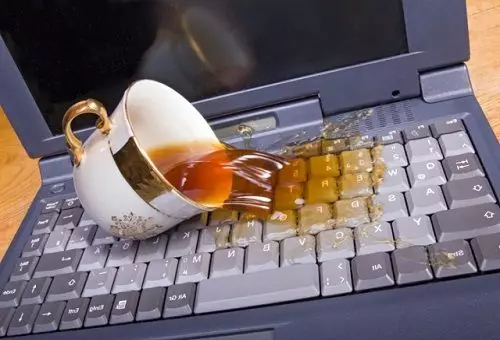الشاي المسكوب على لوحة مفاتيح الكمبيوتر المحمول