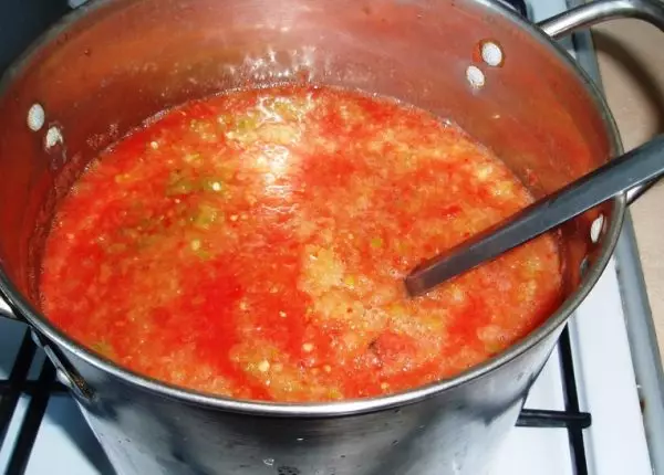 Caviar from zucchini and tomatoes is brewed in a saucepan