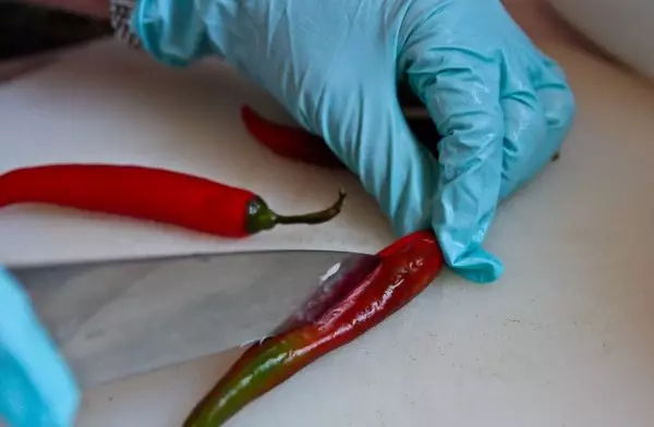 Ang mga talamak na peppers ay pinutol sa dalawang bahagi
