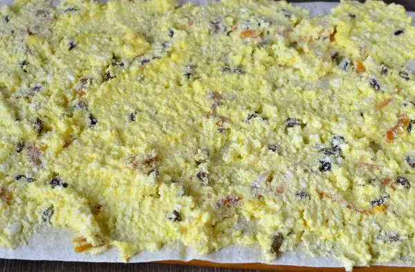 Satu lapisan keju kotej dengan telur dan buah-buahan kering pada sekeping pita nipis