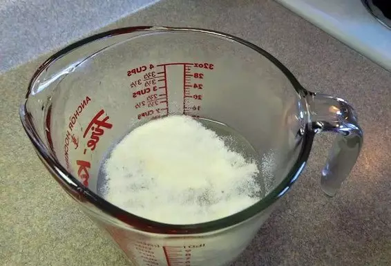 Instant gelatin i en glasmätkanna med vatten