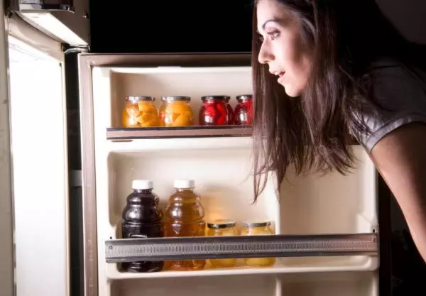 Το κορίτσι κοιτάζει στο ψυγείο