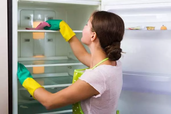 Fille lave un réfrigérateur