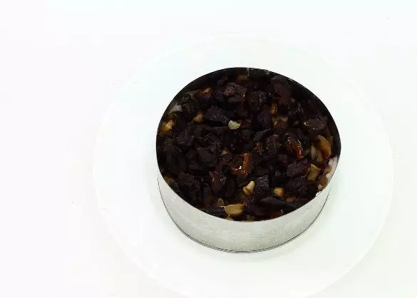 The layer of finely chopped prunes in the molding ring with other ingredients