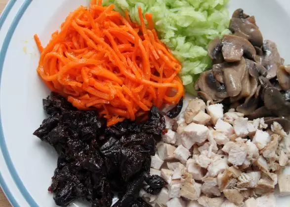 Produk siap untuk salad dengan wortel ayam, prune dan korea di atas piring besar