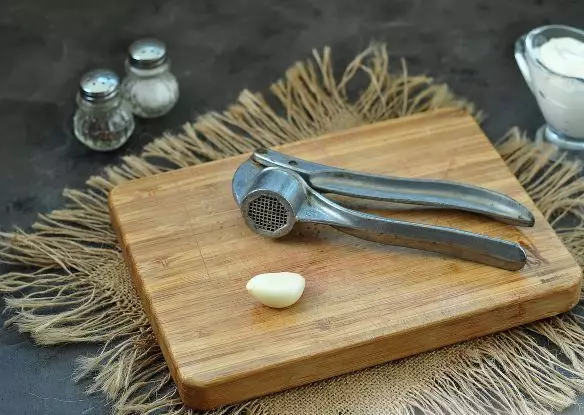 Sbucciato dalle bucce di garofano aglio e stampa su un tagliere di legno