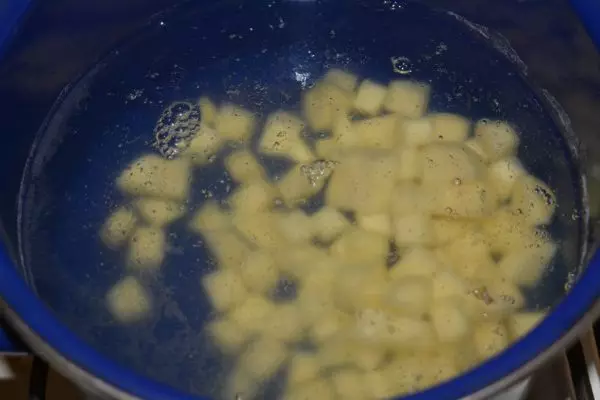 Cubes of raw potatoes in a saucepan with water