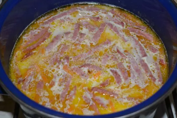 Suppe med grøntsager, ost og pølse i en kasserolle