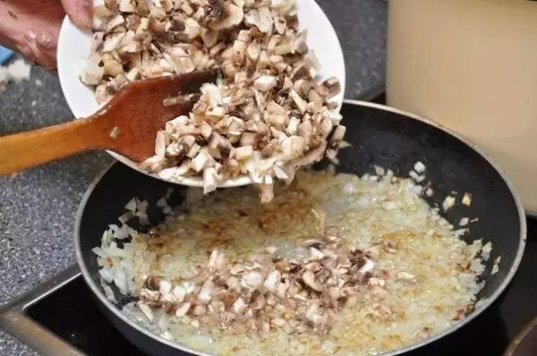 Roasted onions in a frying pan and finely chopped mushrooms