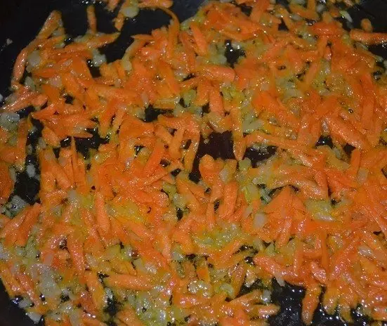 卷曲胡萝卜与在煎锅中的洋葱