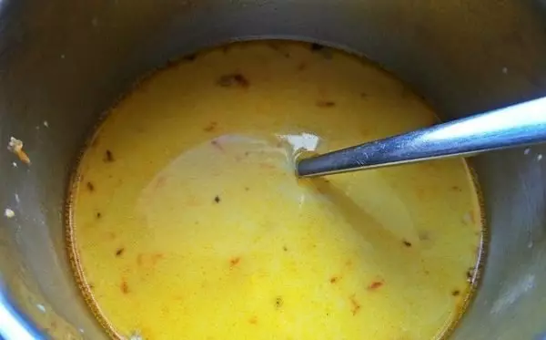 Soup with melted cheese and a mixture of fried vegetables in a saucepan