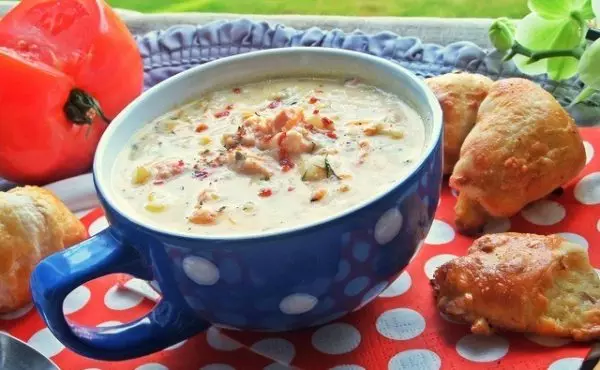 Cheese soup with red fish and cheese in a cup on the table