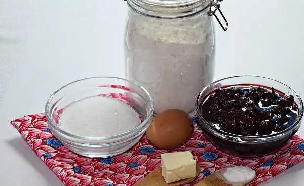 Produkter för matlagningstårta med körsbärssylt på bordet