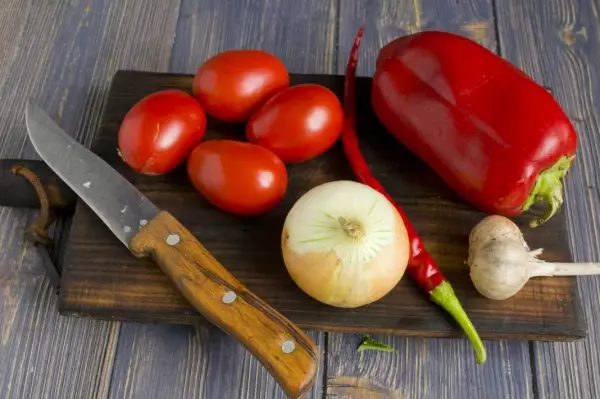 Grøntsager, kniv og skærebræt på bordet