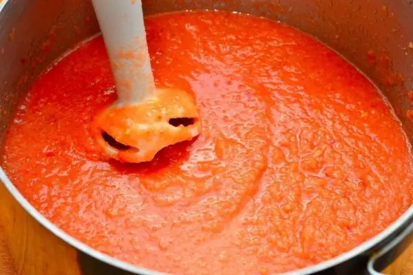 Nedsenkbar blender i en gryte med tomatpasta