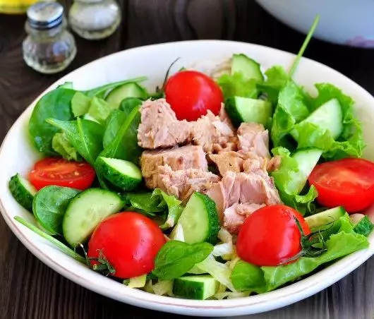 Listovi salata, komadi svježih krastavaca i rajčice, konzervirana tuna