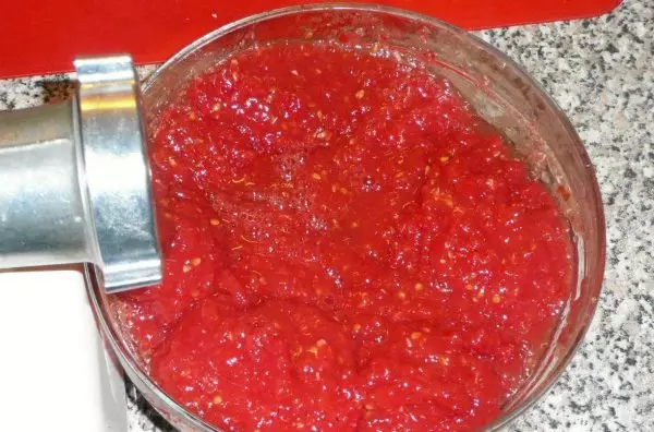 Tempel tomat dari tomat dalam penggiling daging