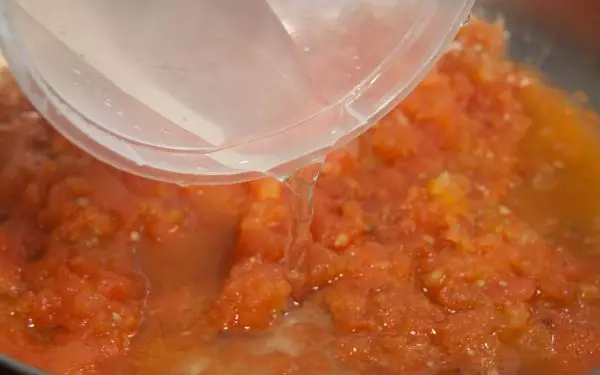 Air dituangkan ke dalam kentang tumbuk tomat