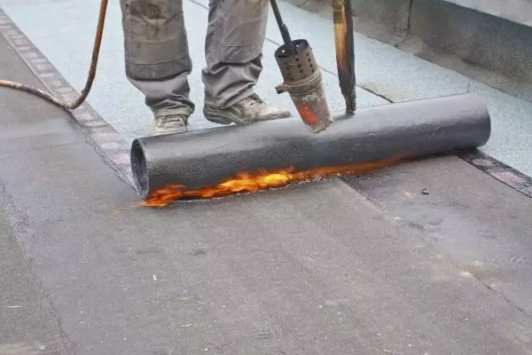 Laying lapisan bitumen karo burner