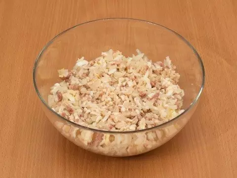 Salada de fígado de bacalhau com arroz cozido sem reabastecimento em recipientes de vidro em uma superfície de madeira