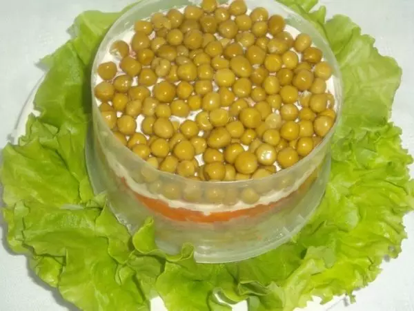 Schicht aus konservierten grünen Erbsen im Formungsring mit anderen Bestandteilen von Schichtsalat