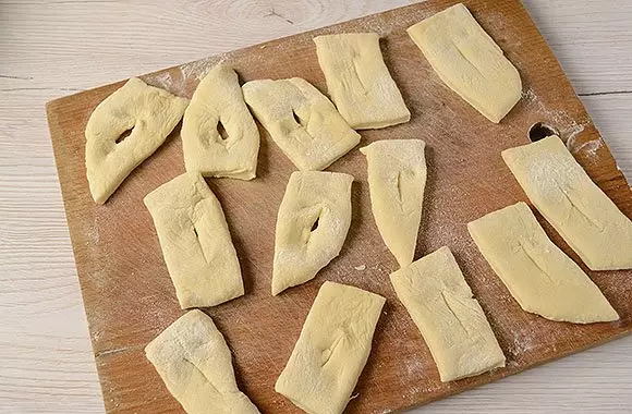 कटिंग बोर्ड वर dough आयताकृती तुकडे कट