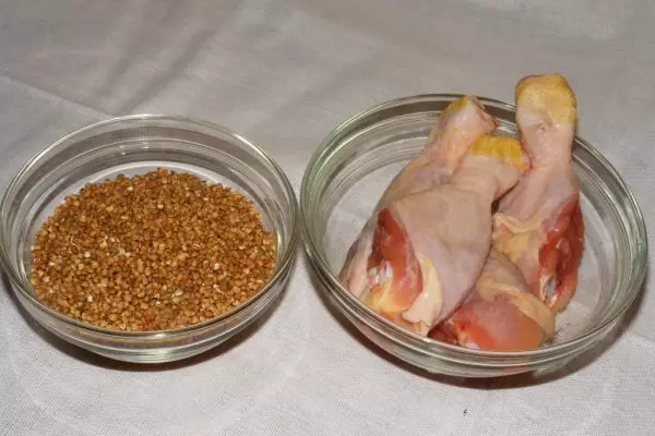 ग्लास बाऊल्स मध्ये buckwheat आणि कच्चे चिकन पाय