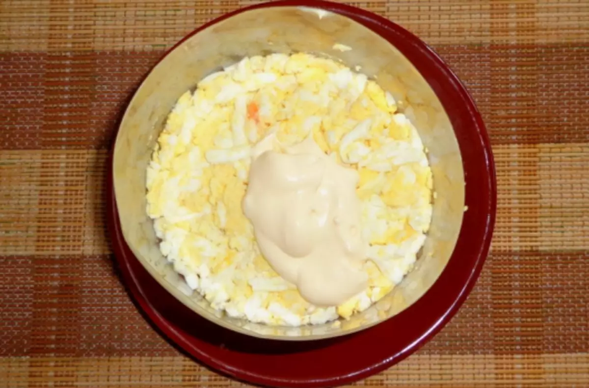 Warstwa startego jajka gotowanych i majonezu w pierścieniu do formowania