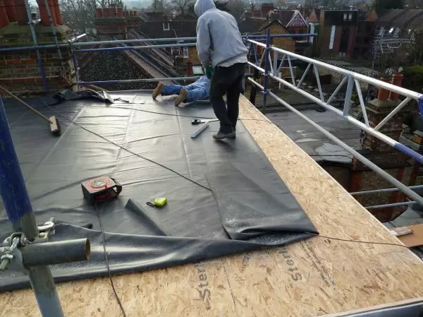Pemasangan atap gulung di atas dasar kayu