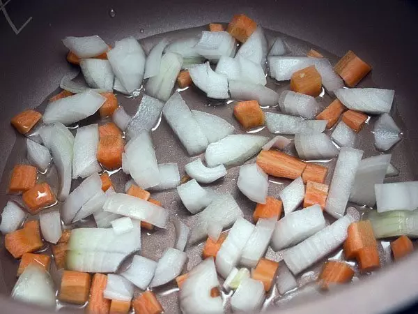 Piezas de zanahorias y cebollas en un tazón de multicantes.